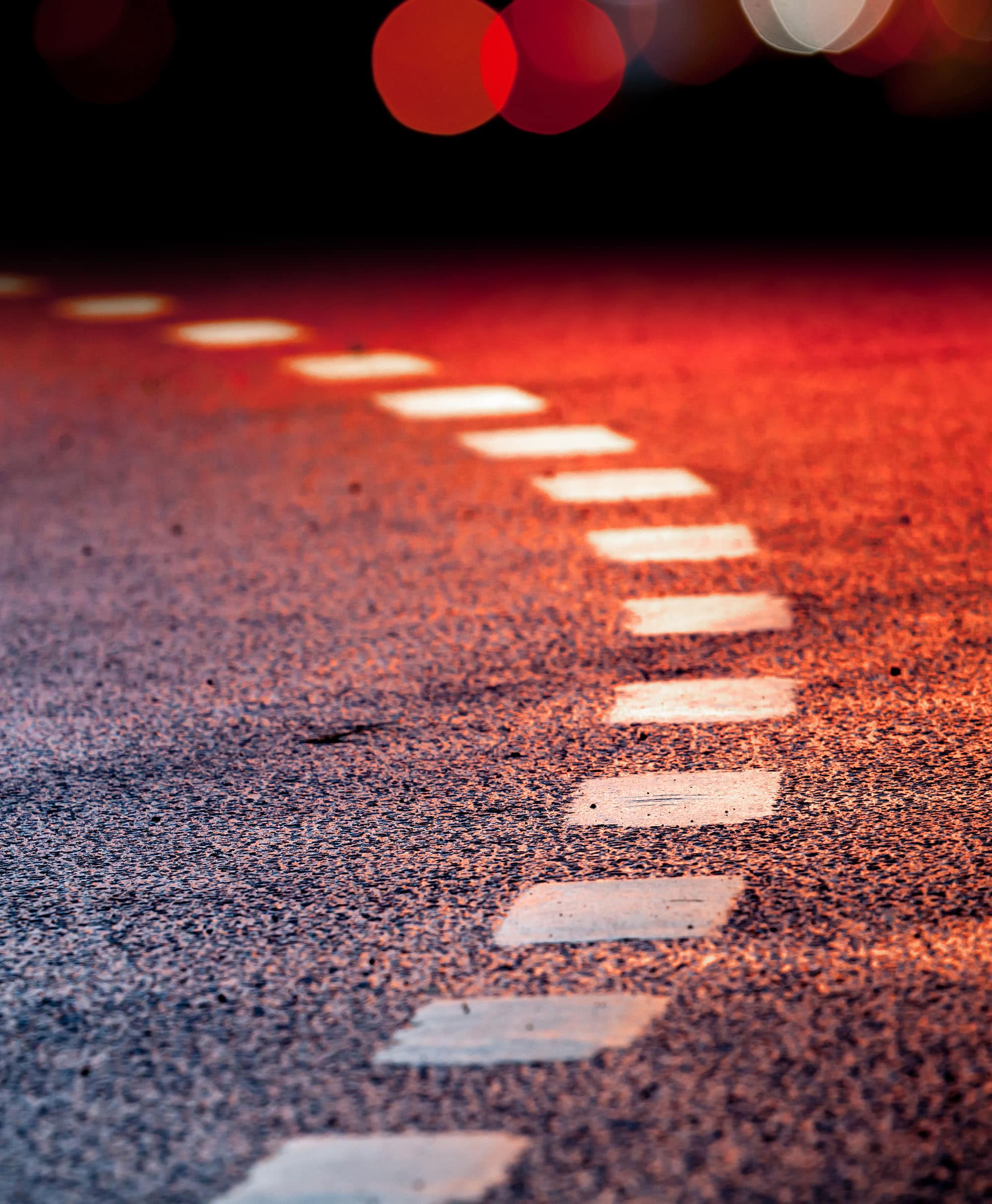 Turning asphalt road with marking lines and bright red reflectio ...